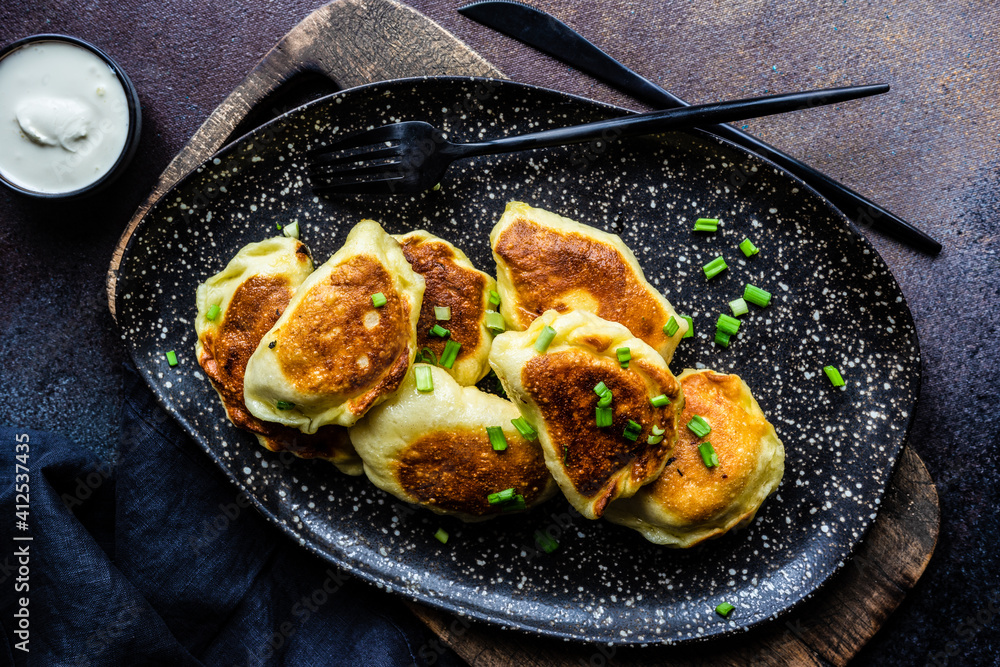 Ukrainian vareniki potato dumplings with chive garnish and sour cream ...