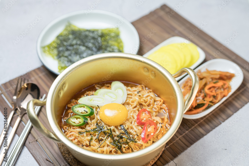Korean traditional Ramyeon noodle with egg yolk, chilli, kimchi in a ...