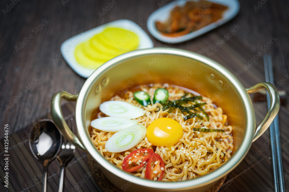 Korean traditional Ramyeon noodle with egg yolk, chilli, kimchi in a ...