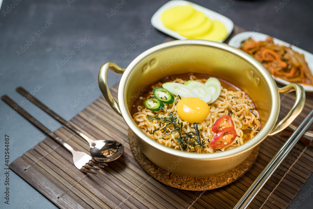 Korean traditional Ramyeon noodle with egg yolk, chilli, kimchi in a ...