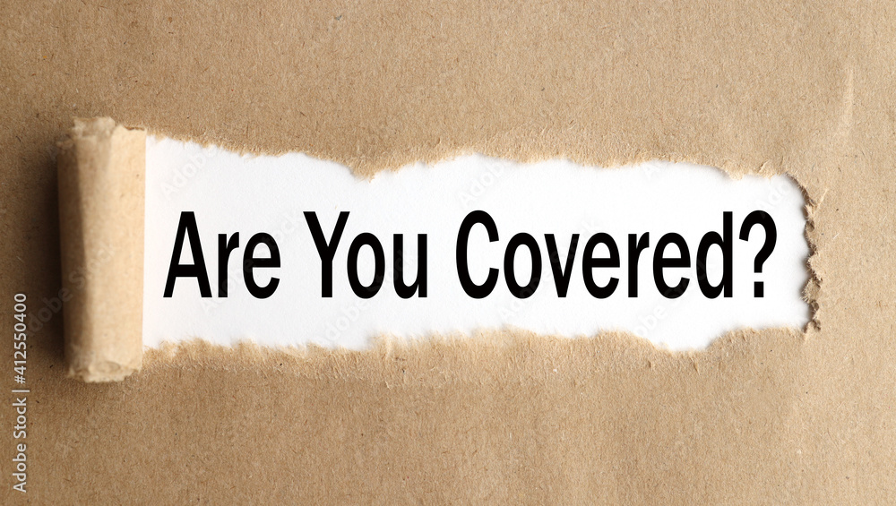ARE YOU COVERED. text on white paper over torn paper background. Stock ...