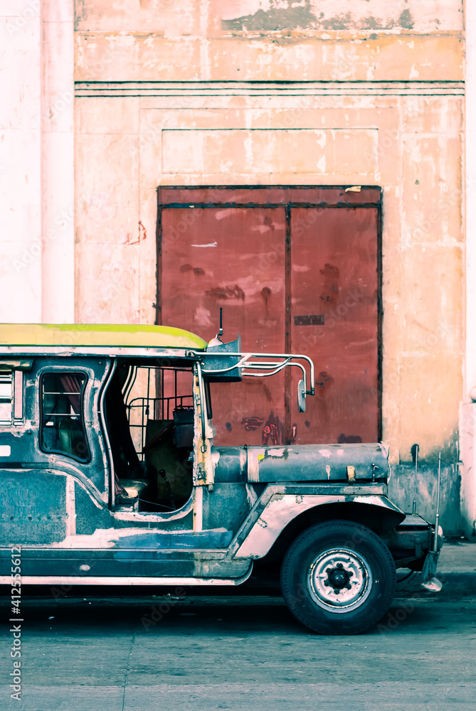 Colorful public utility vehicle parked beside warehouse in the City of ...