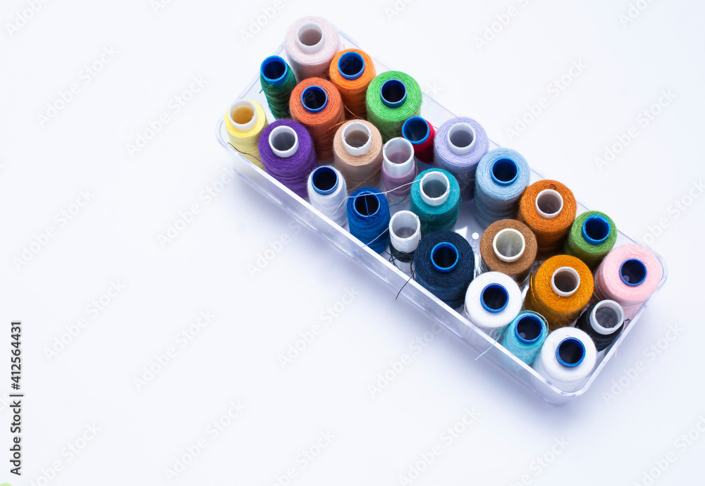 colorful different threads in transparent box on white background with ...