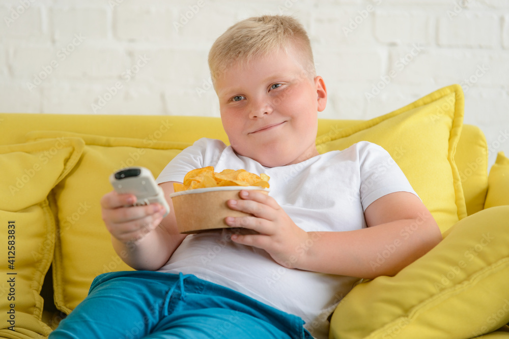 Lazy fat boy eating chips and watching TV Stock Photo | Adobe Stock