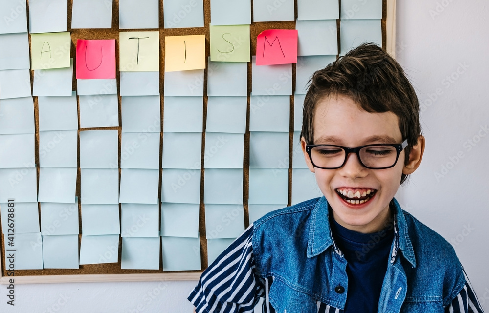 Portrait of cheerful autism boy with glasses in blue shirt front a ...