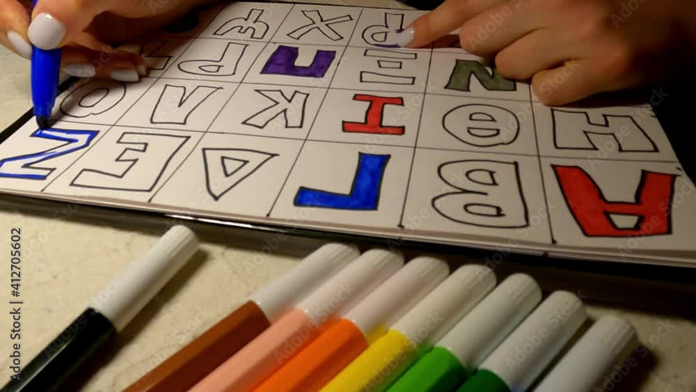 Preschool female teacher coloring letters of greek alphabet letters ...