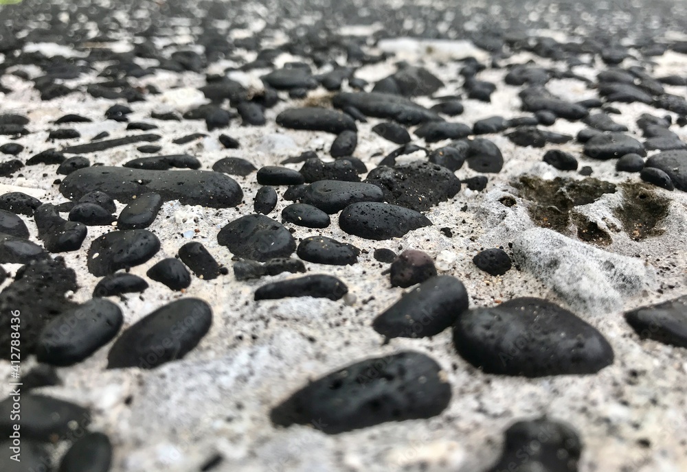 Closeup picture of a pathway made with black lava stone pebbles ...