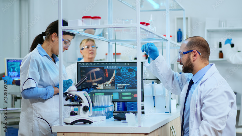 Team of medical research scientists conducting vaccine development with ...