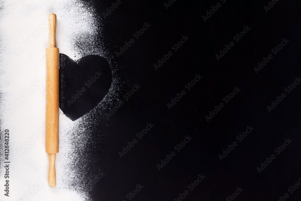 Baking background with heart shape and flour on the dark table. Rolling ...