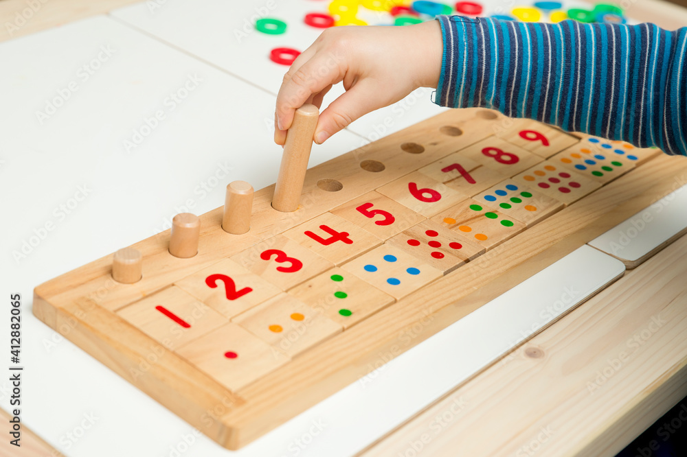 Child playing with different color wooden rings. Sequence, fine motor ...