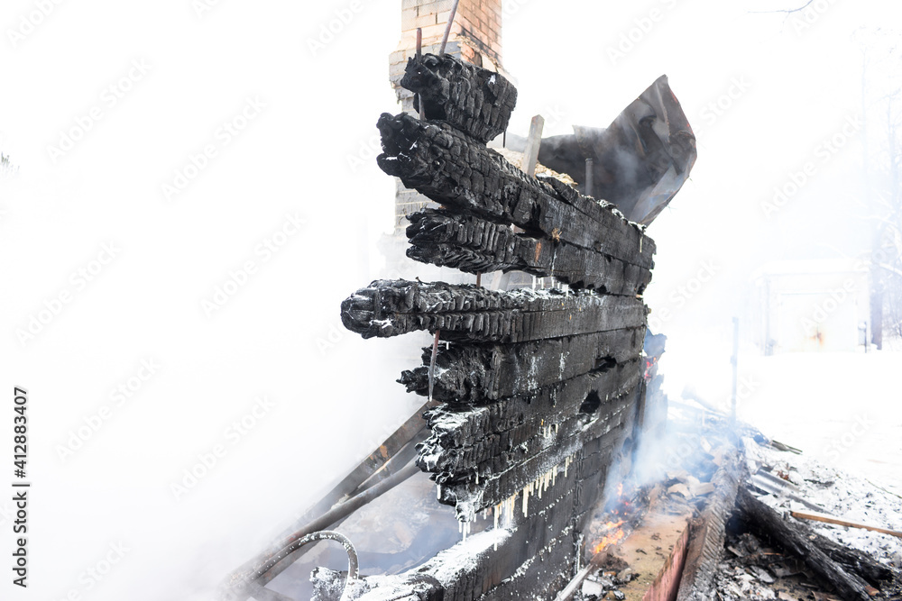 Charred wooden walls of a house after a fire. Burnt boards in a burnt ...