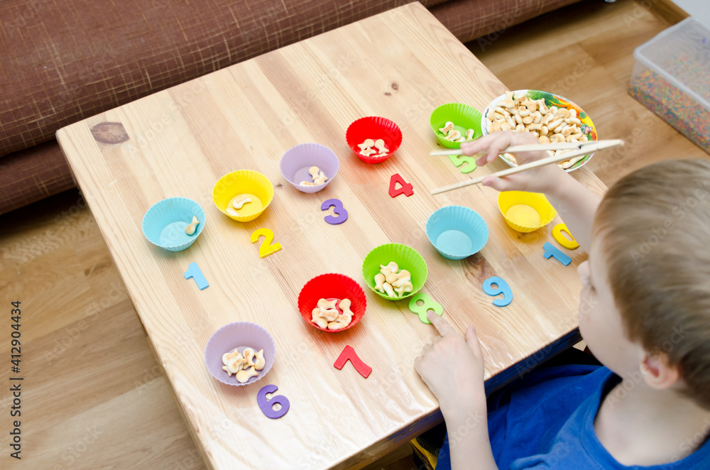 Little child doing simple math exercises. Early education, counting ...