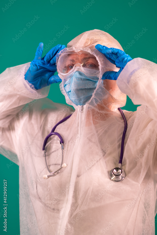 Female doctor in PPE suit uniform with stethoscope on the shoulder ...