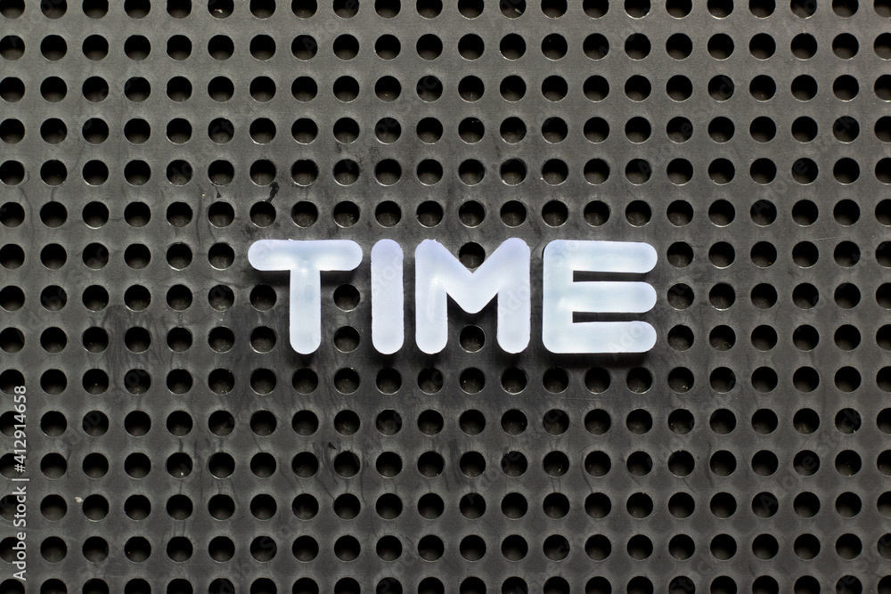 White color letter in word time on black pegboard background Stock ...