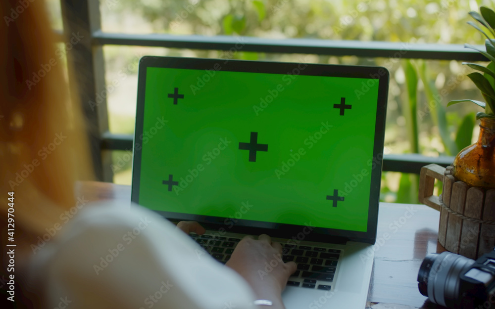 Summer terrace table with mock up green screen laptop person typing on ...