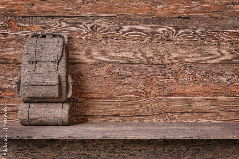 Sculpted wood backpack on a shelf with copy space and rustic wood ...