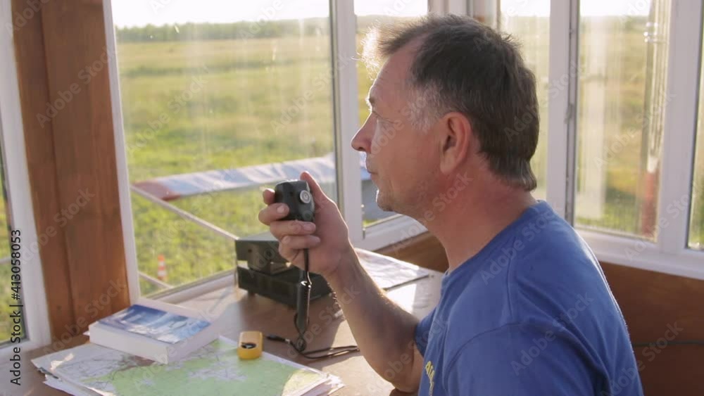 Airman dispatcher talking to pilot by walkie-talkie and discussing ...