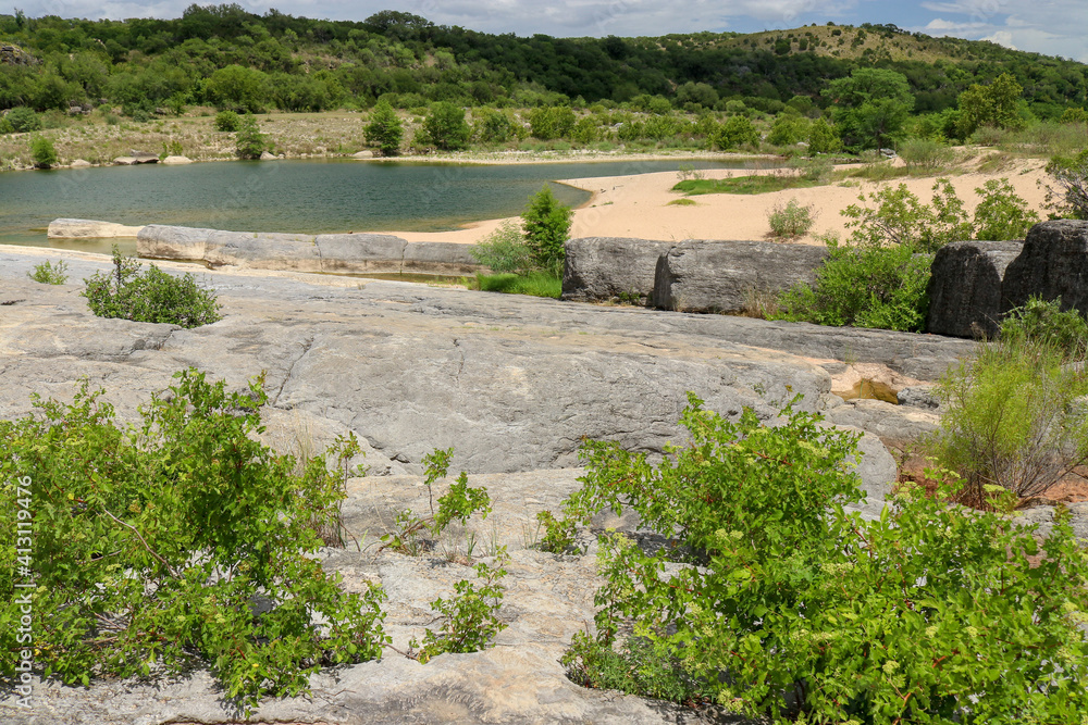 The Pedernales river flows over natural limestone levees creating ...