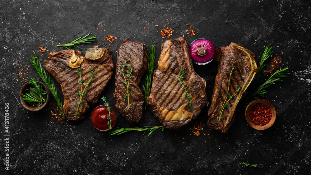 Steak menu. Juicy grilled steaks on a black stone background: t-bone ...