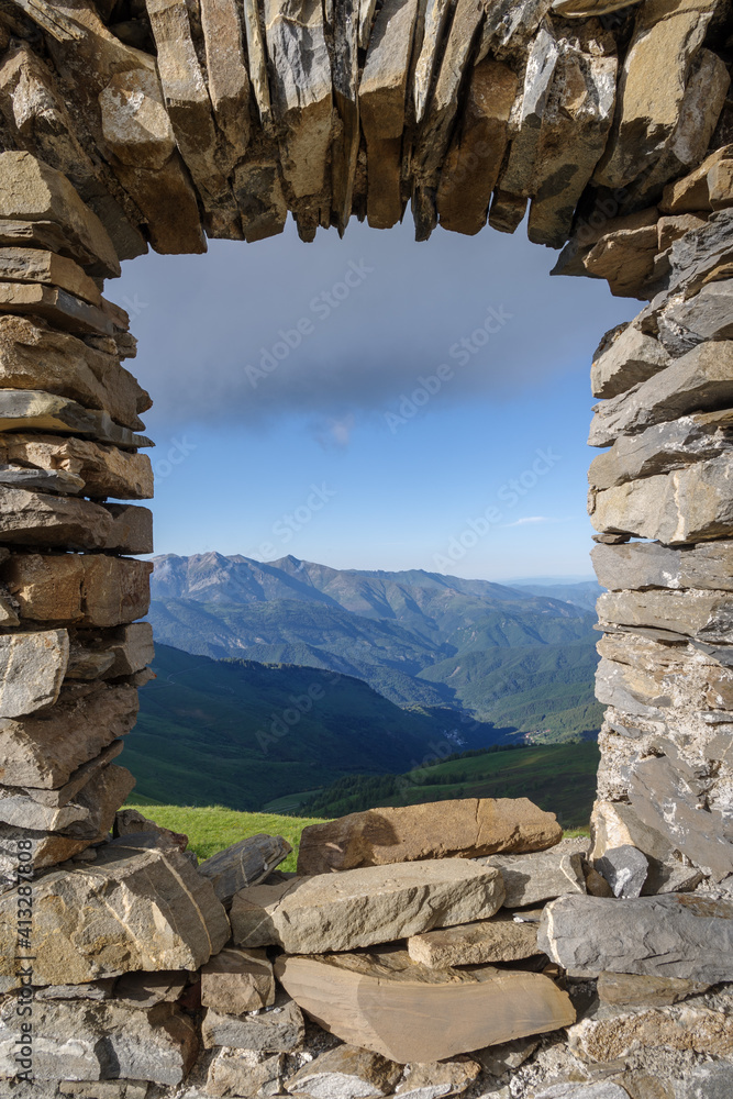 Ruined stone arch window overlooking the scenic landscape of Ligurian ...