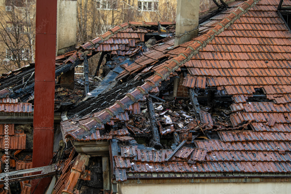 House Rooftop Fire Damage. Charred roof trusses and burnt furniture. A ...