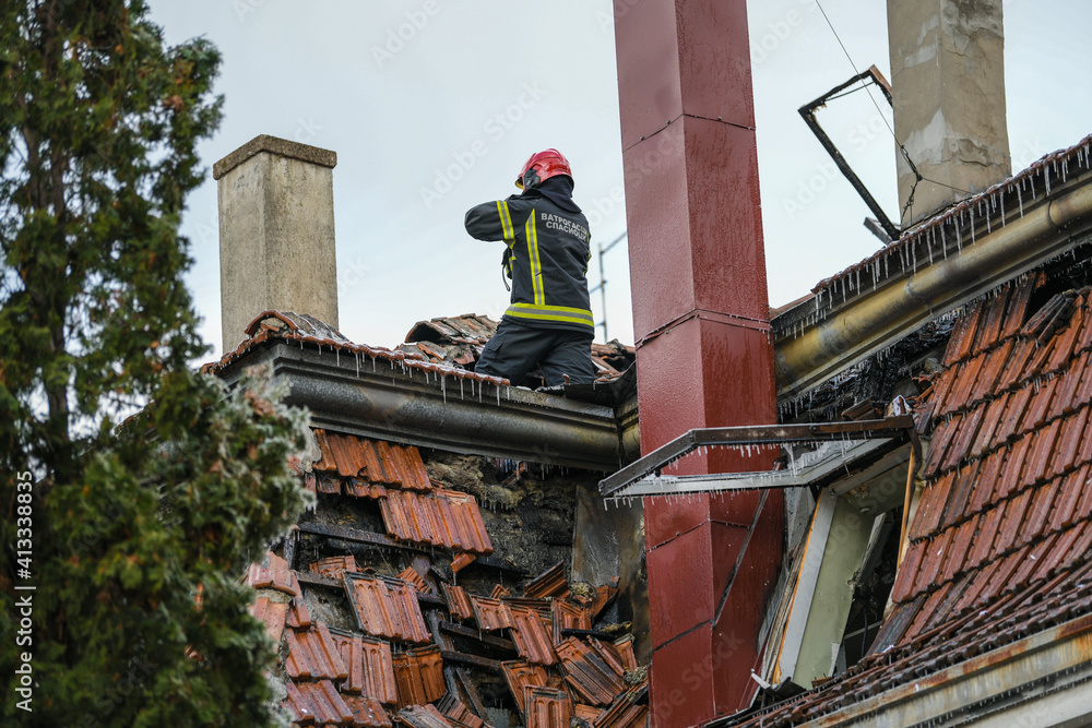 Firefighter inside a collapsed roof of a house is looking for survivors ...