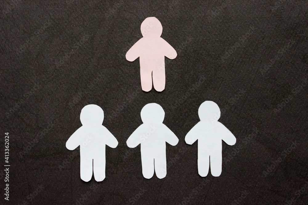 Silhouettes of three men, arranged in a row, cut from paper. Over them ...
