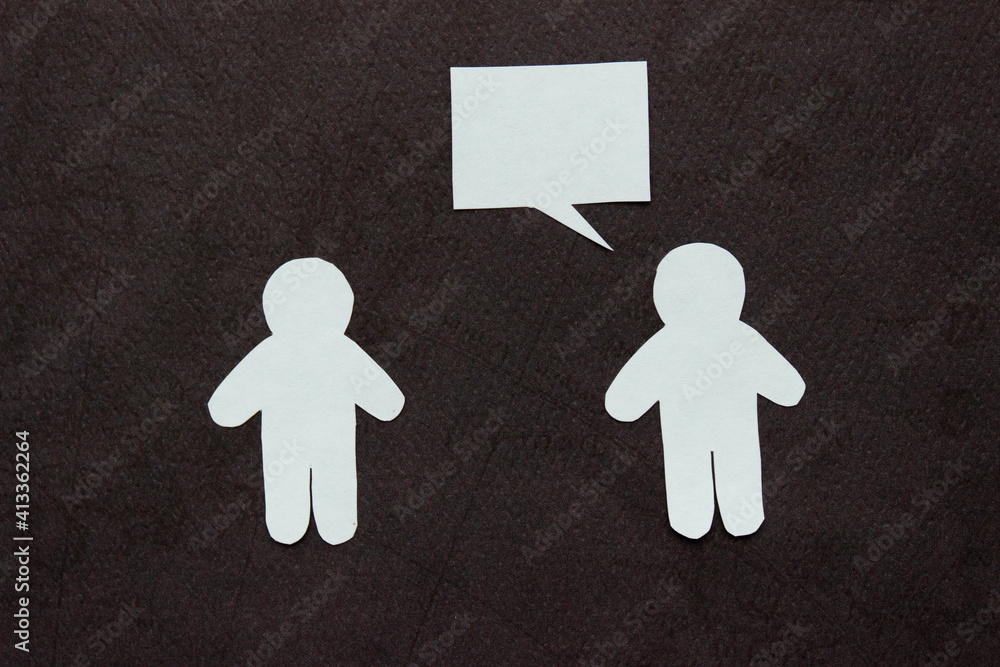 Silhouettes of two people cut from white paper on a black background ...