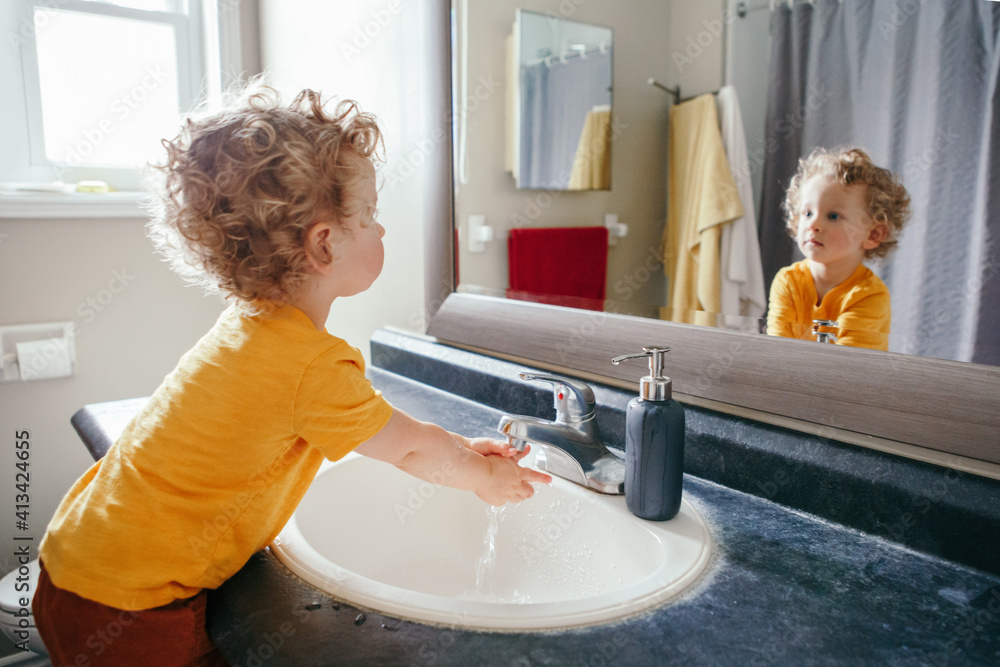 Little Caucasian boy toddler washing hands in bathroom at home. Health ...