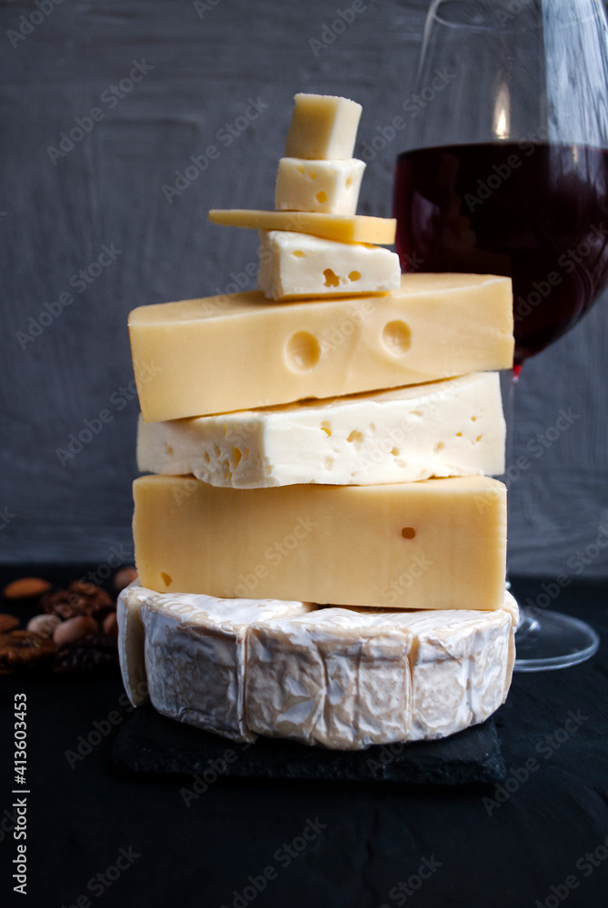 Assortment of different cheese types on dark and white background ...