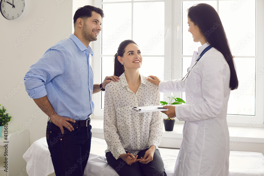 Foto de Happy married couple seeing family doctor. Clinician talking to ...