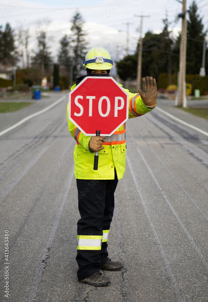 Masked flagger at work holding stop sign Stock Photo | Adobe Stock