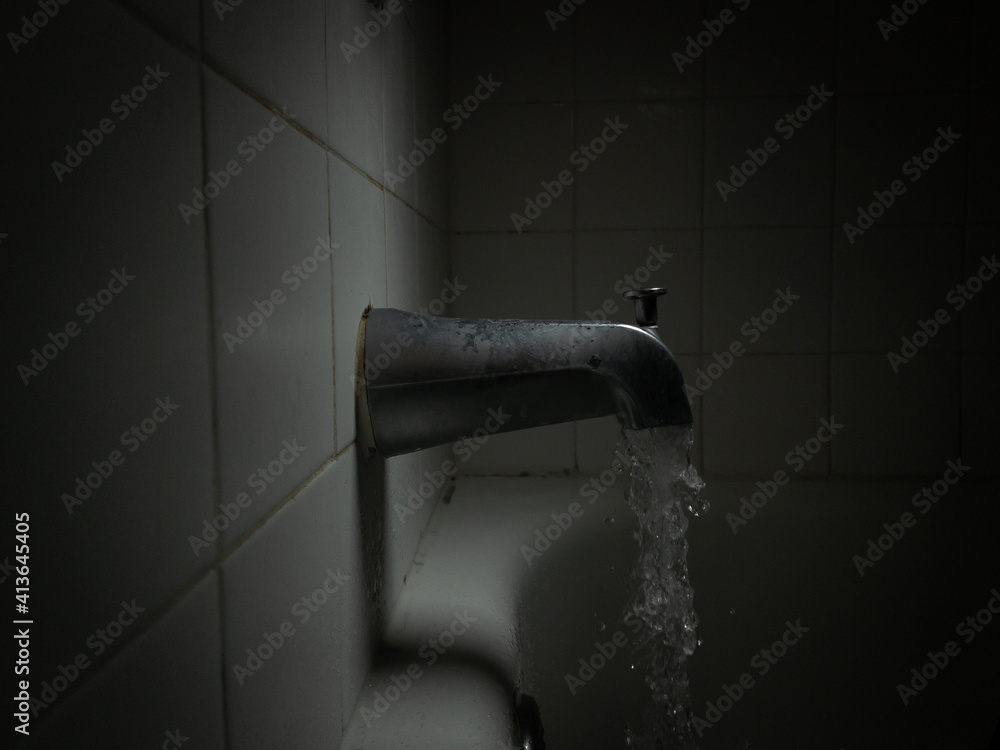 Dark, Moody Side View of a Running Bathtub Faucet, with Water Pouring ...