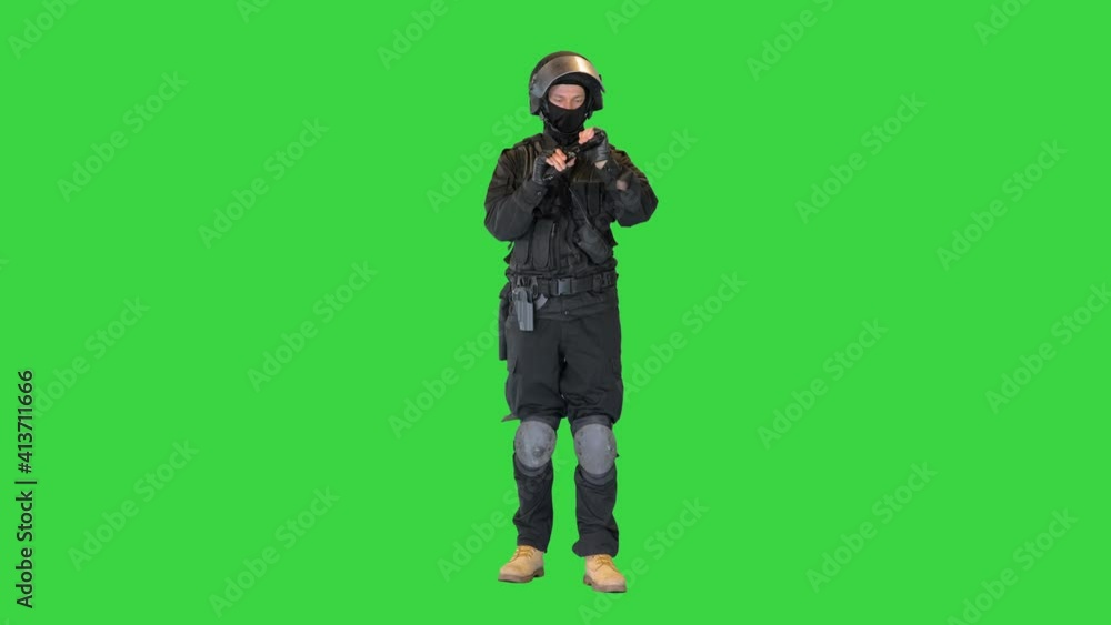 Police tactical officer checking his hand gun and folding hands on a ...