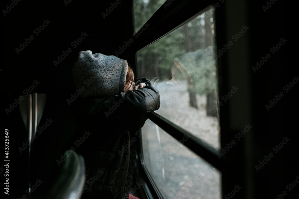 Boy looking through window while sitting in tour bus at Yosemite ...