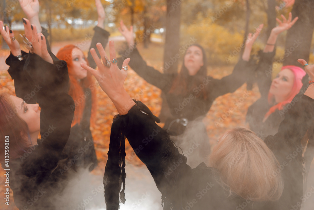 Coven of witches, a group of friends as witches on Halloween perform a ...