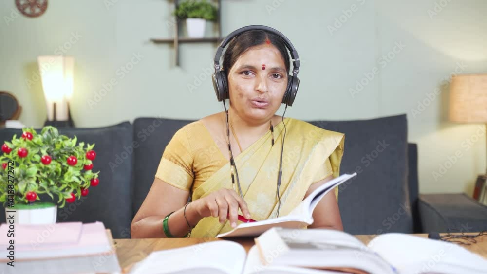 Vídeo do Stock: Indian woman busy explaining from book during online ...