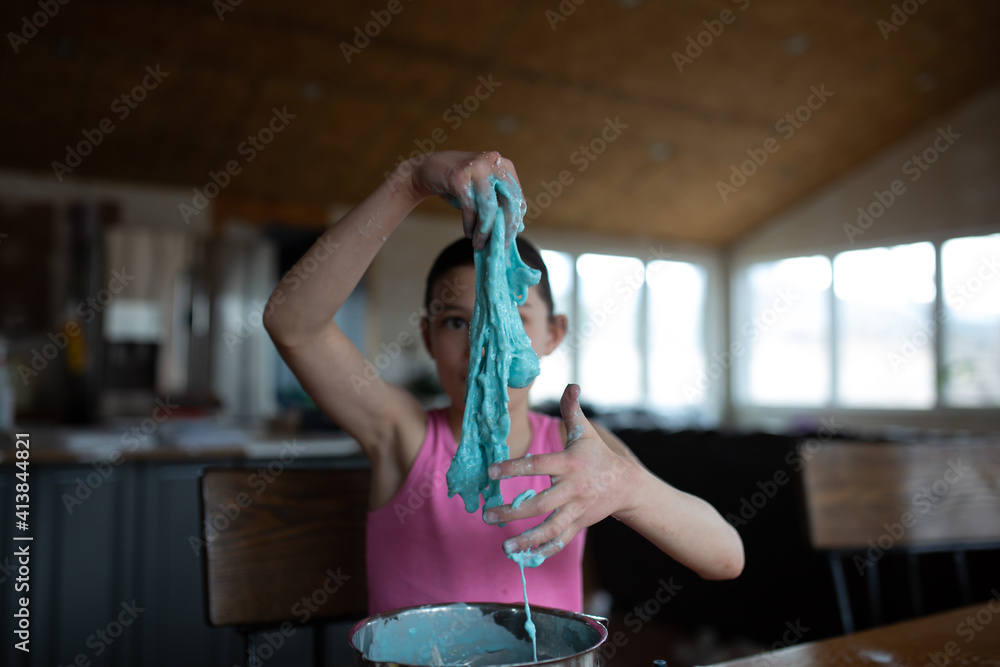 Tween making blue slime at home Stock Photo | Adobe Stock