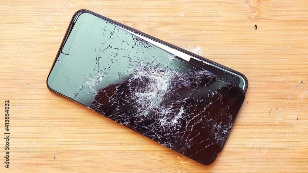 Shattered smartphone display destroyed by hammer. Blank broken phone ...
