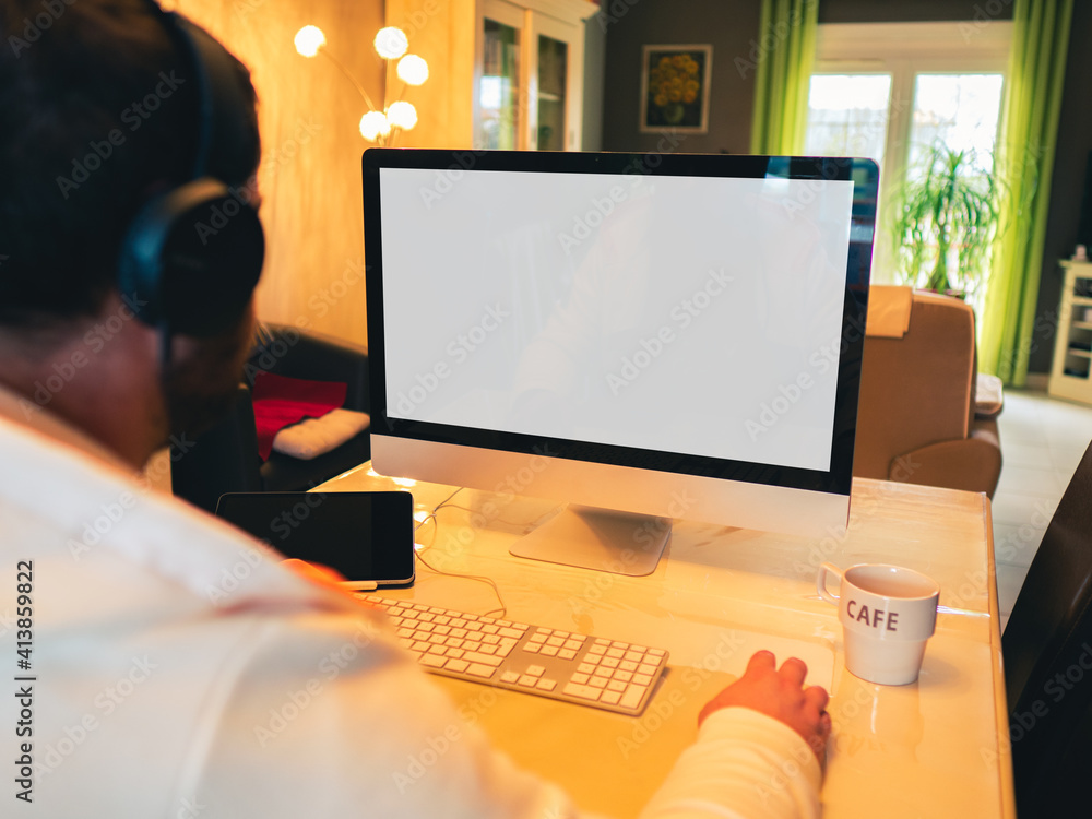 Teleworking - Young man working from his home in his living room, on ...