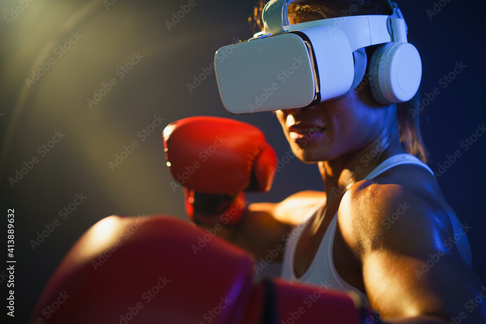 Medium close up shot of Asian woman wearing VR headset to exercise with ...
