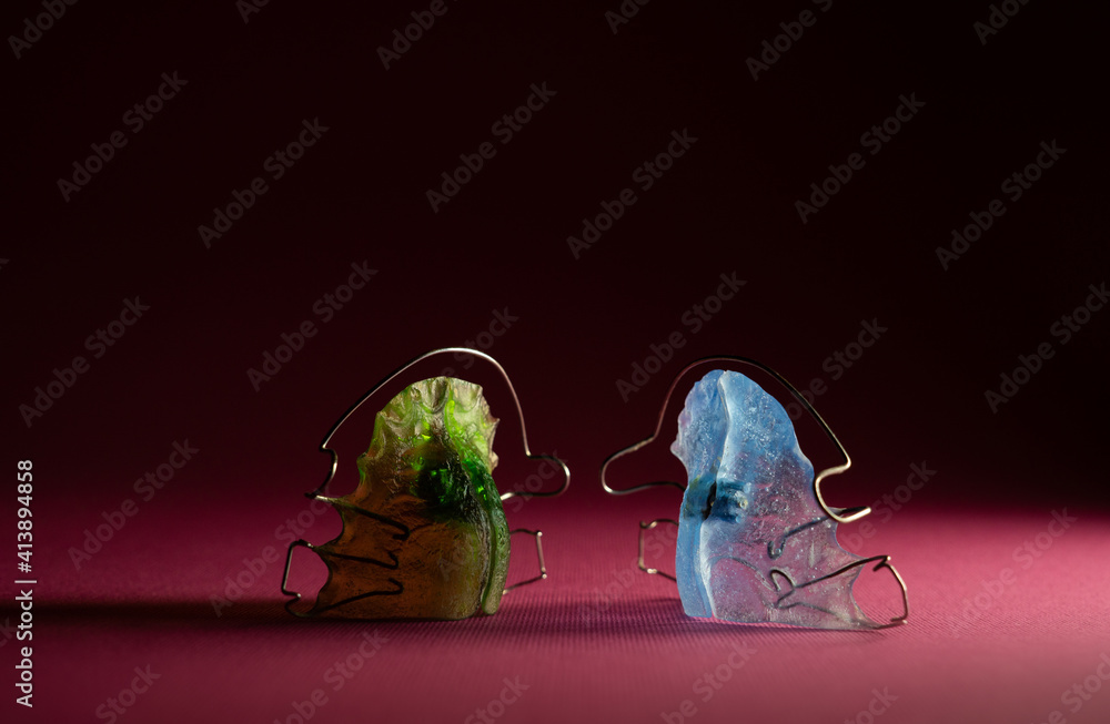 Flat view of two old dental prostheses made of green and blue plastic ...