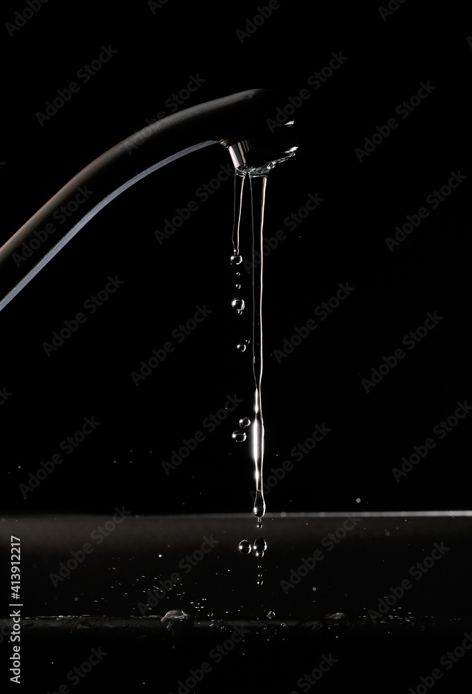 Leaking tap water against a black background Stock Photo | Adobe Stock