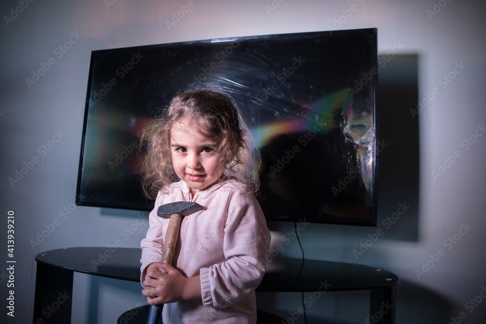 Cute little girl standing in front of a TV with broken screen holding a ...