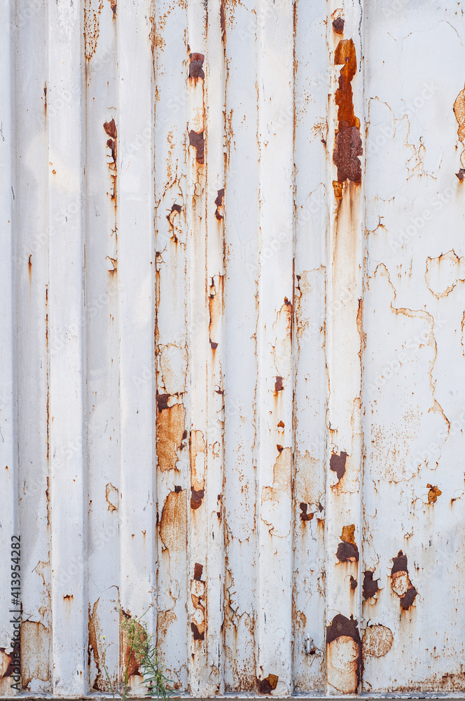 Old rusty metal container with white cracked paint, reddish-brown rust ...