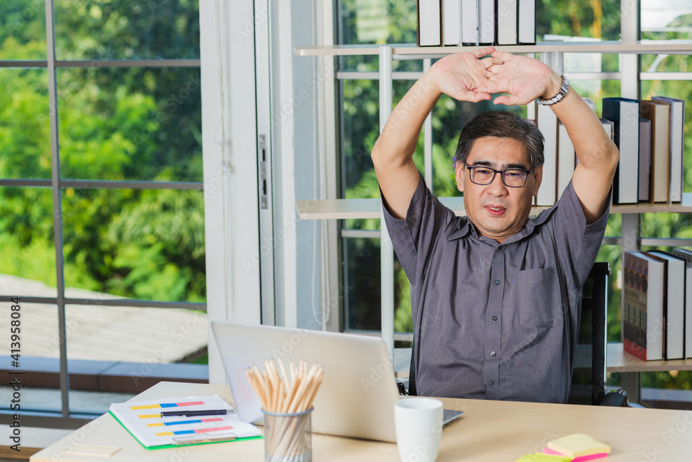 Asian businessman tired overworked he stretch oneself on the desk ...