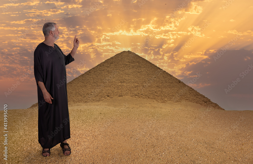 Foto de An Egyptian in black robe stands in front of the pyramid of ...