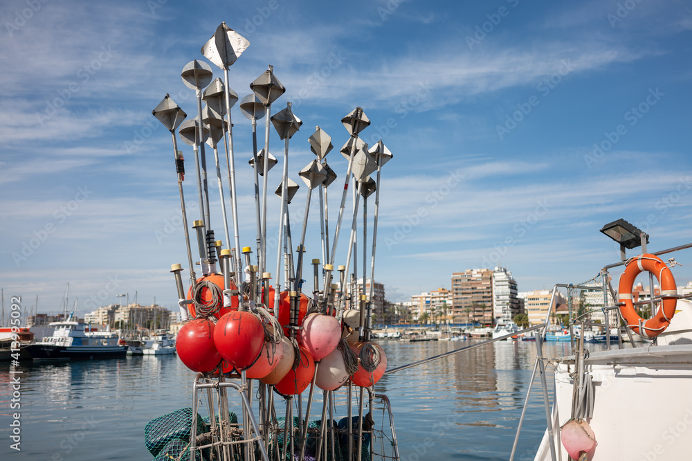 There are many buoys attached to metal rods on a fish trawler. The ship ...