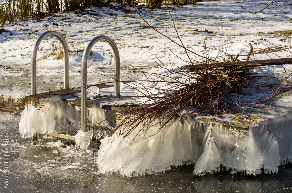 frozen bathing jetty. ice and frozen snow covered dock at frozen pool ...