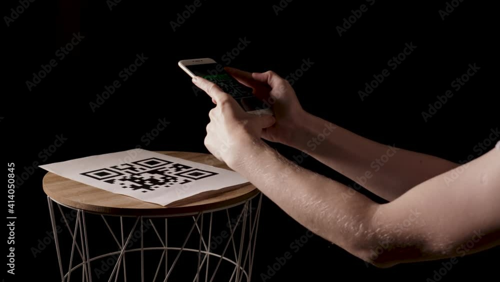 Female hands scan a QR code on paper using a mobile phone, smartphone ...
